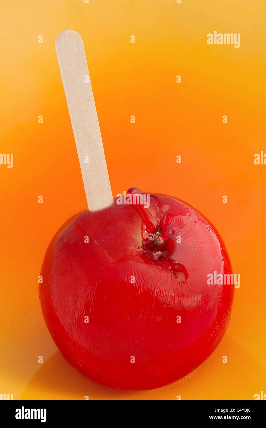candy red apple over an orange and red background - colorful fruit ...