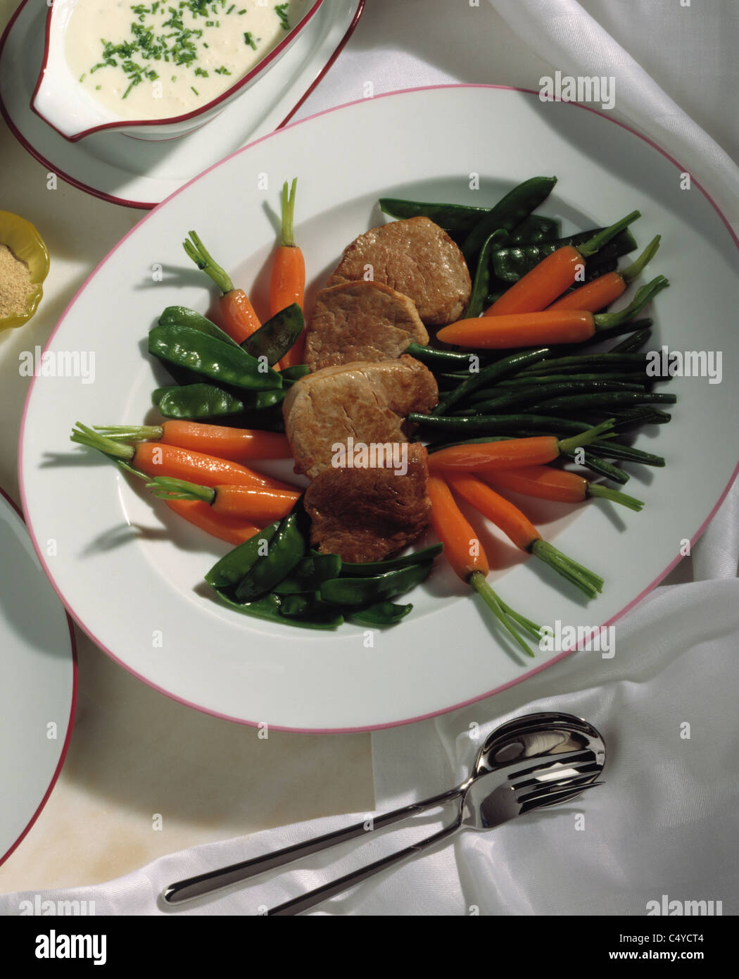 Medaillons of veal with spring vegetables Stock Photo - Alamy