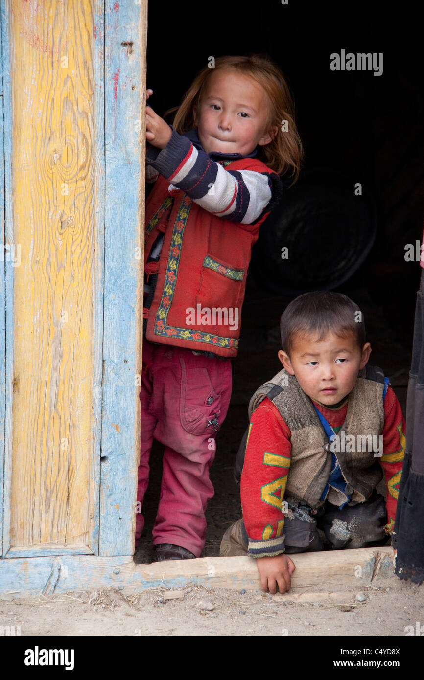 Two children in the doorway of a home on outskirts of Olgii with Kazakh ...