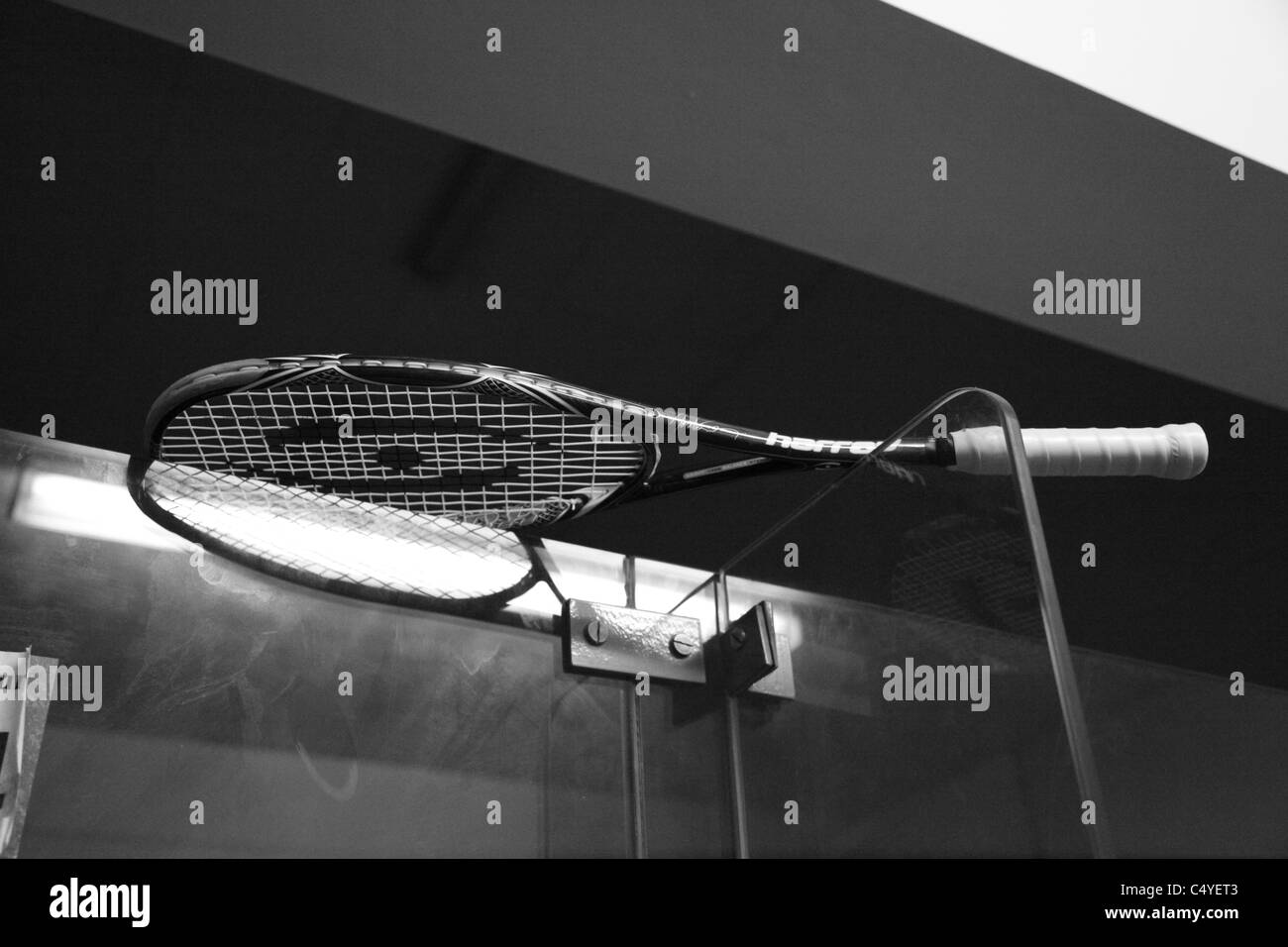 A squash racket perched on top of the back wall of a glass backed ...