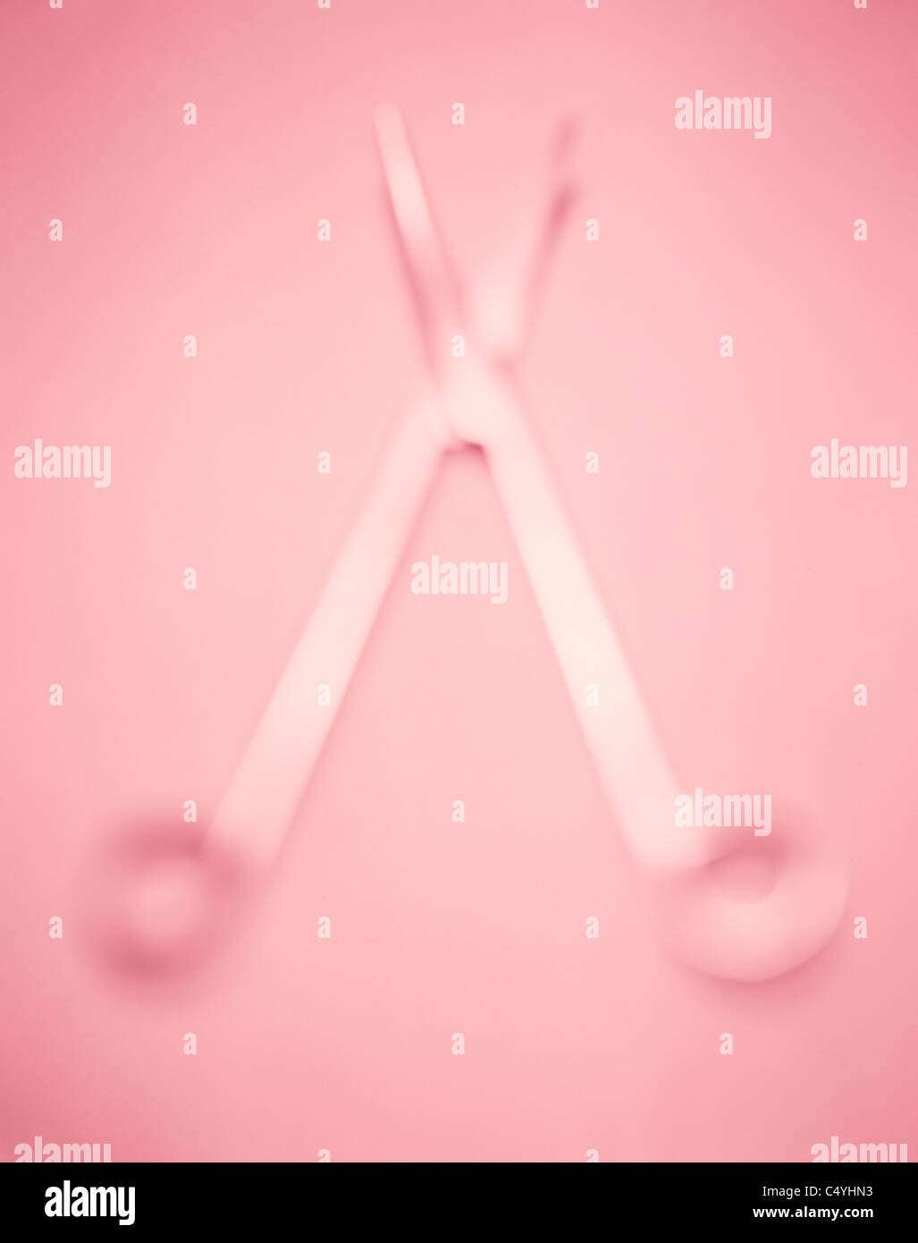 Metal surgical scissors on a pink background with soft selective focus ...