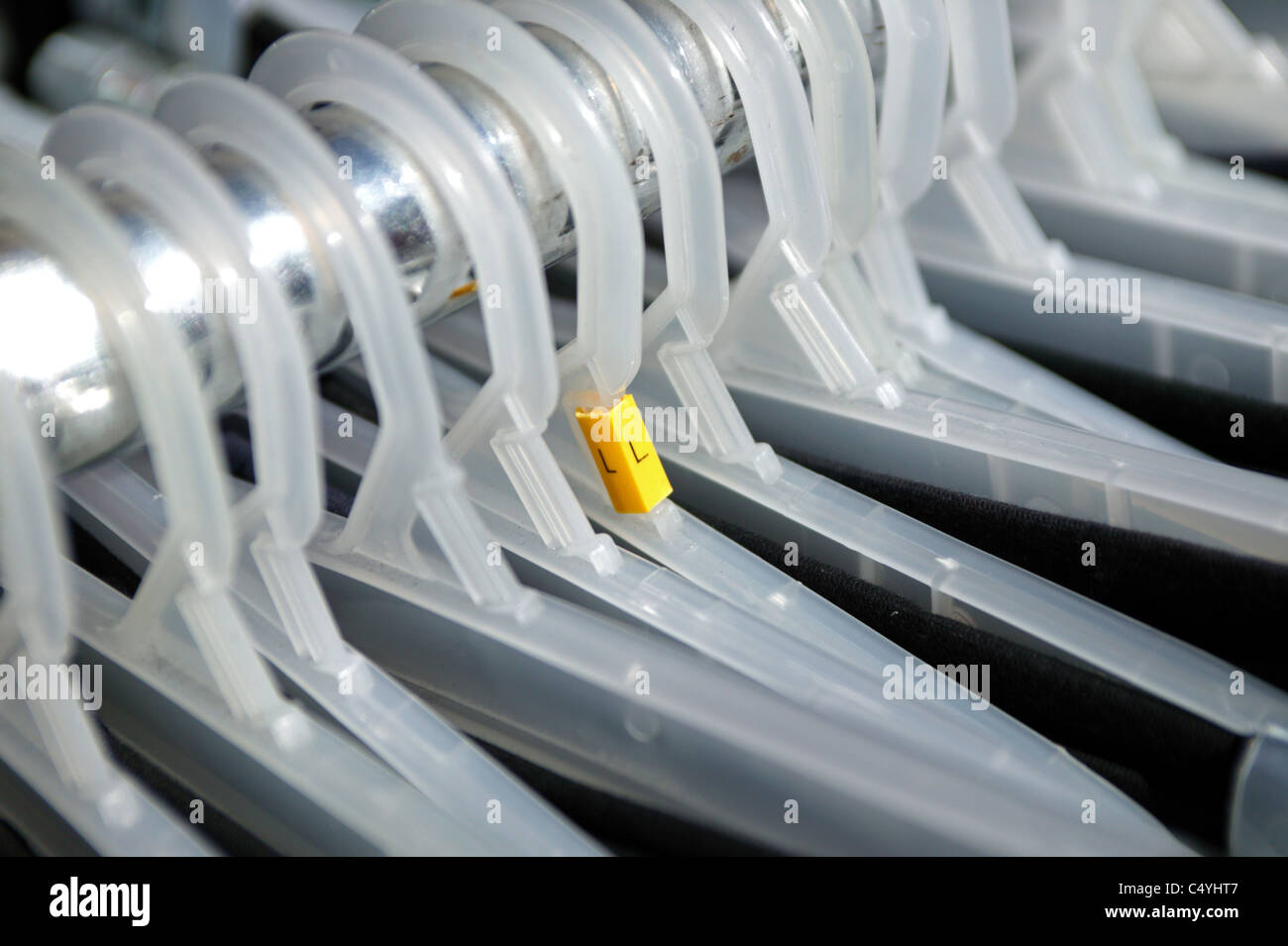 A row of plastic clothing hangers with a "large" marking label Stock ...
