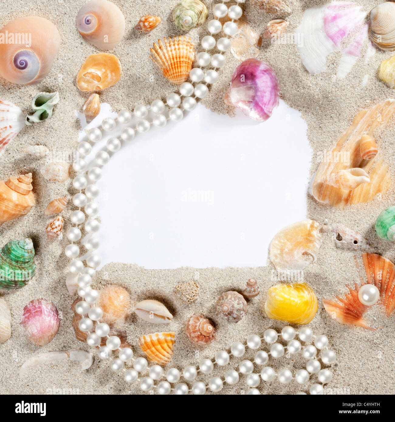 frame composition over beach sand beach with blank paper with pearls ...