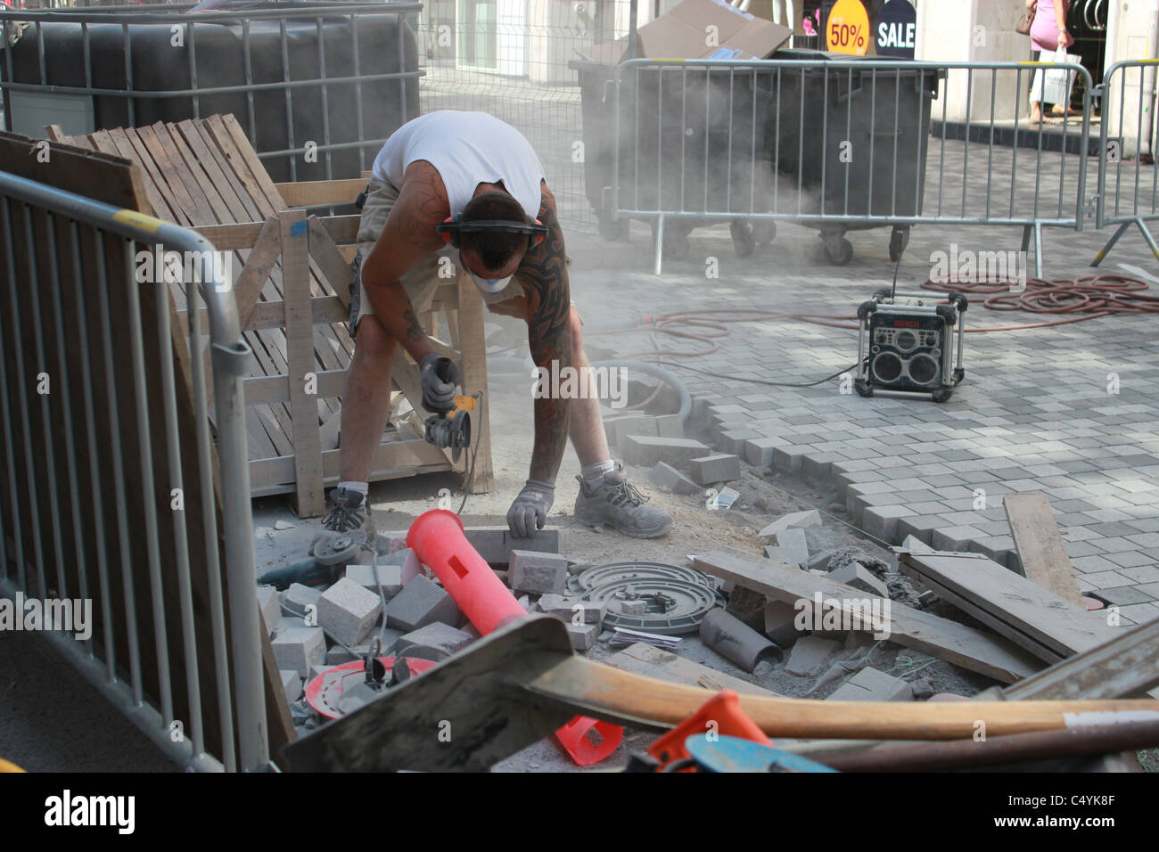 Construction worker is repairing pavement Stock Photo - Alamy