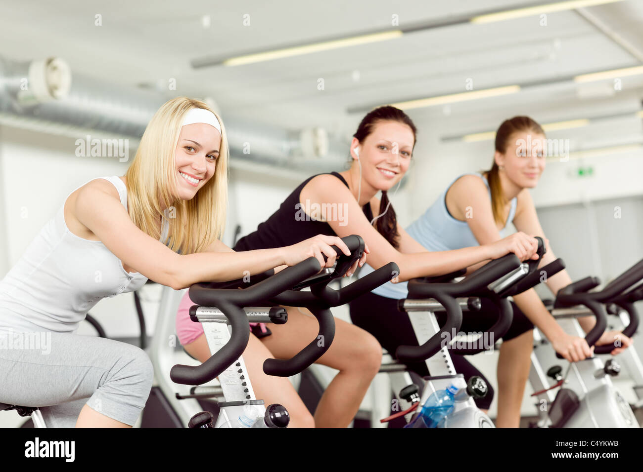 Fitness young woman on gym bike spinning indoor cardio exercise Stock ...
