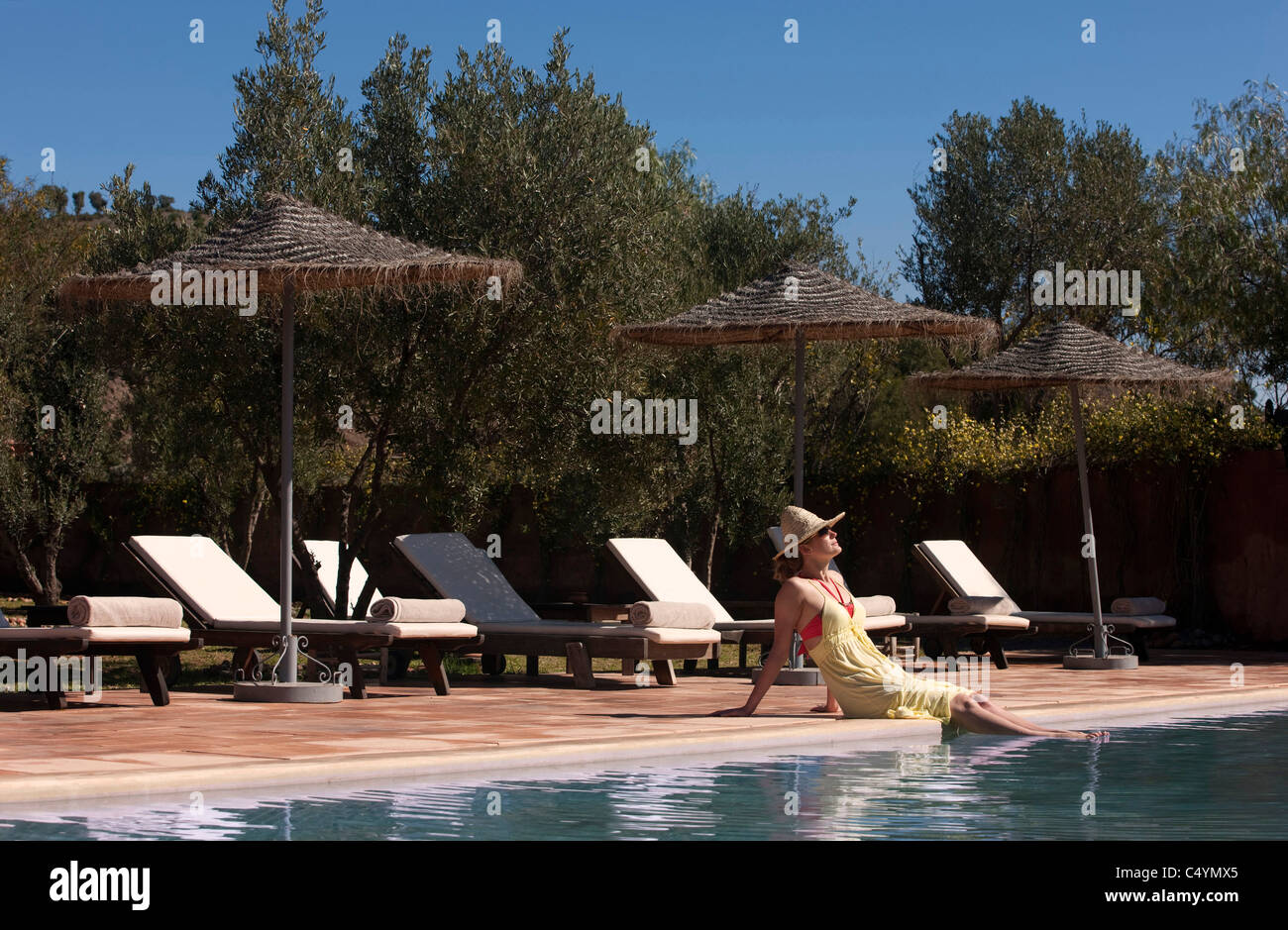 Soaking up the sun next to the pool. Kasbah Bab Ourika, Morocco Stock ...