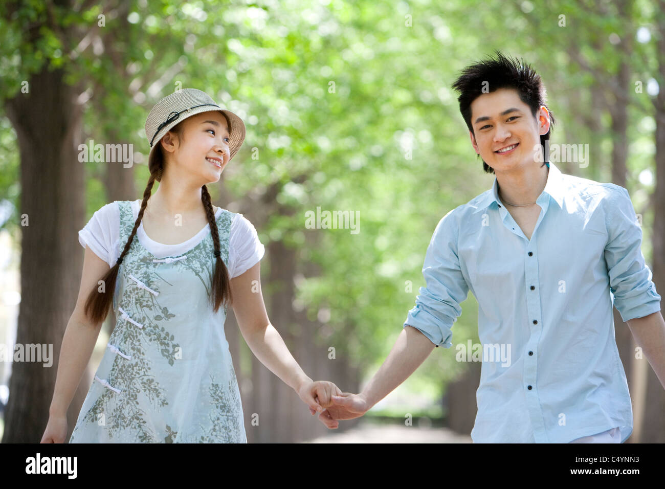 Happy Young Couple Walking Through the Park Stock Photo - Alamy