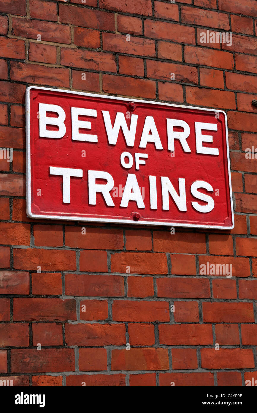 Beware of Trains Sign on a brick wall Stock Photo - Alamy