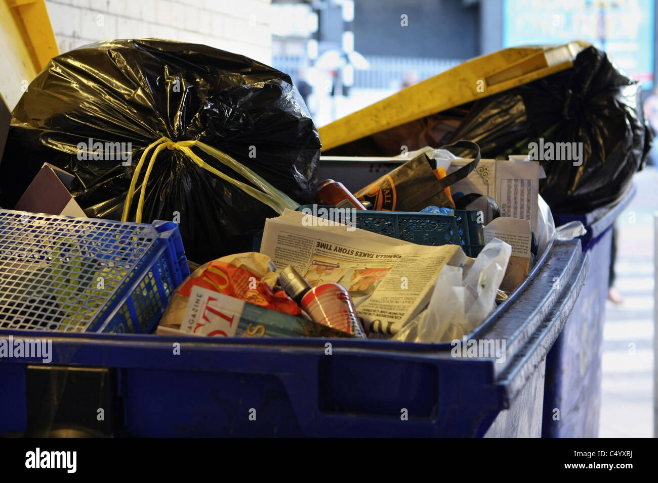 Two commercial wheelie bins full of rubbish - one lid open and one lid ...