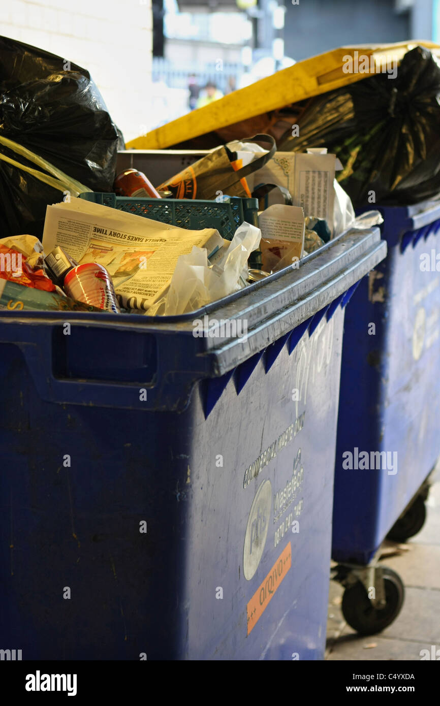 Two commercial wheelie bins full of rubbish in bright sunlight Stock ...