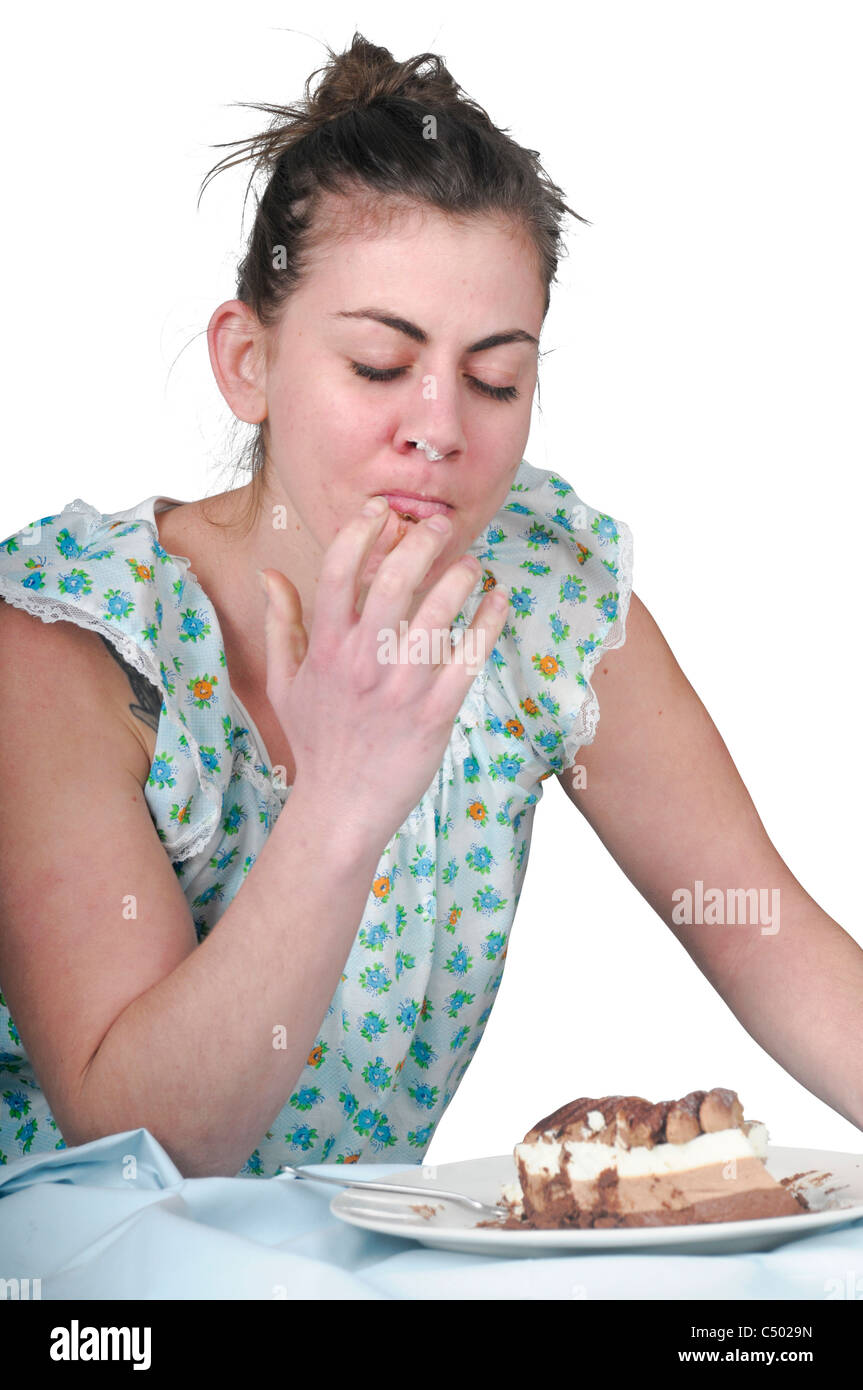 Female eating disorder. Young woman craves a cream cake late at night ...