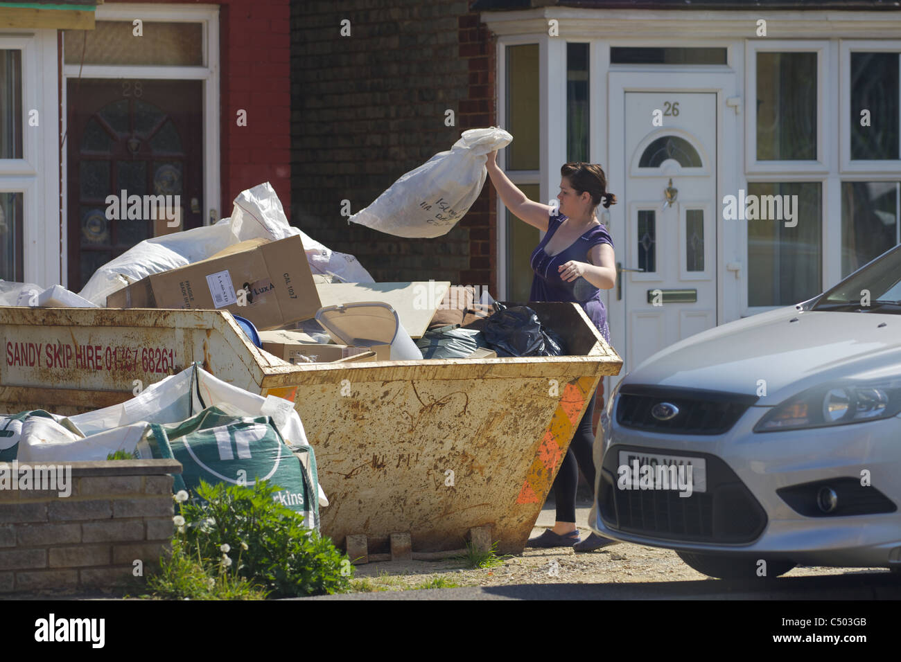 Loading a skip with rubbish, Bedfordshire, England Stock Photo - Alamy