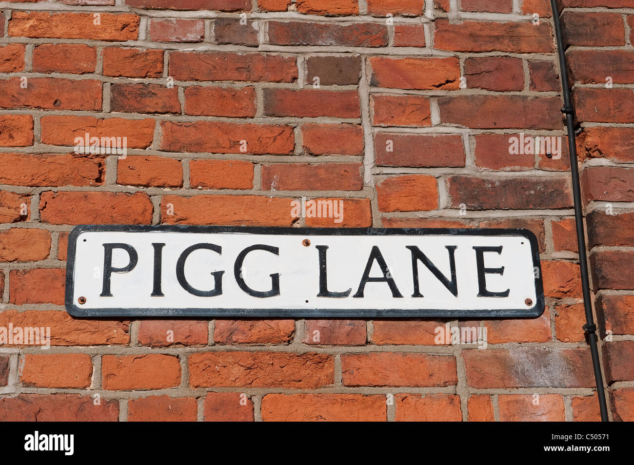 Traditional street name plate fixed to a brick wall on Pigg Lane in ...