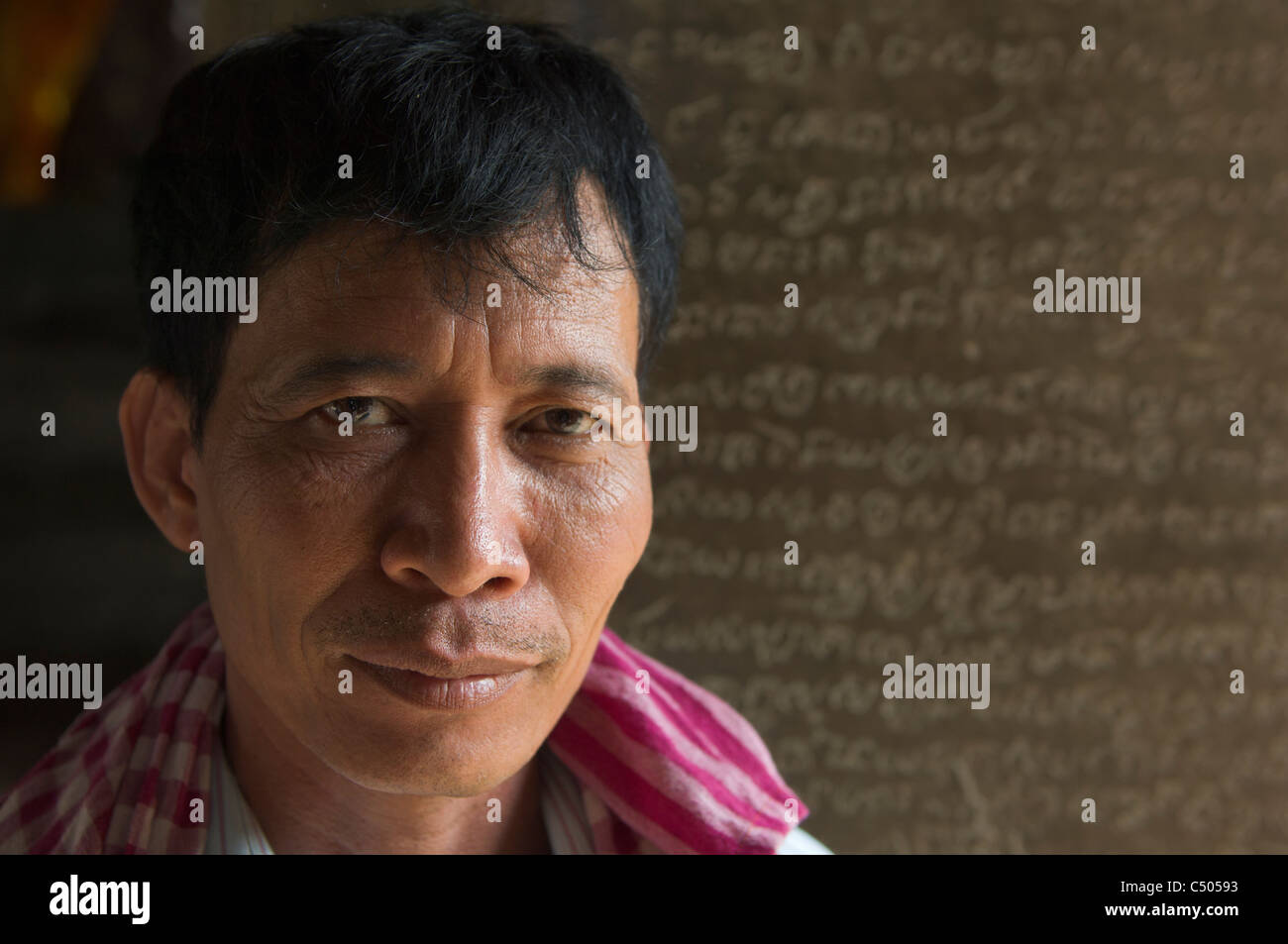 Cambodian man in front of carved Khmer script in Central Sanctuary on ...