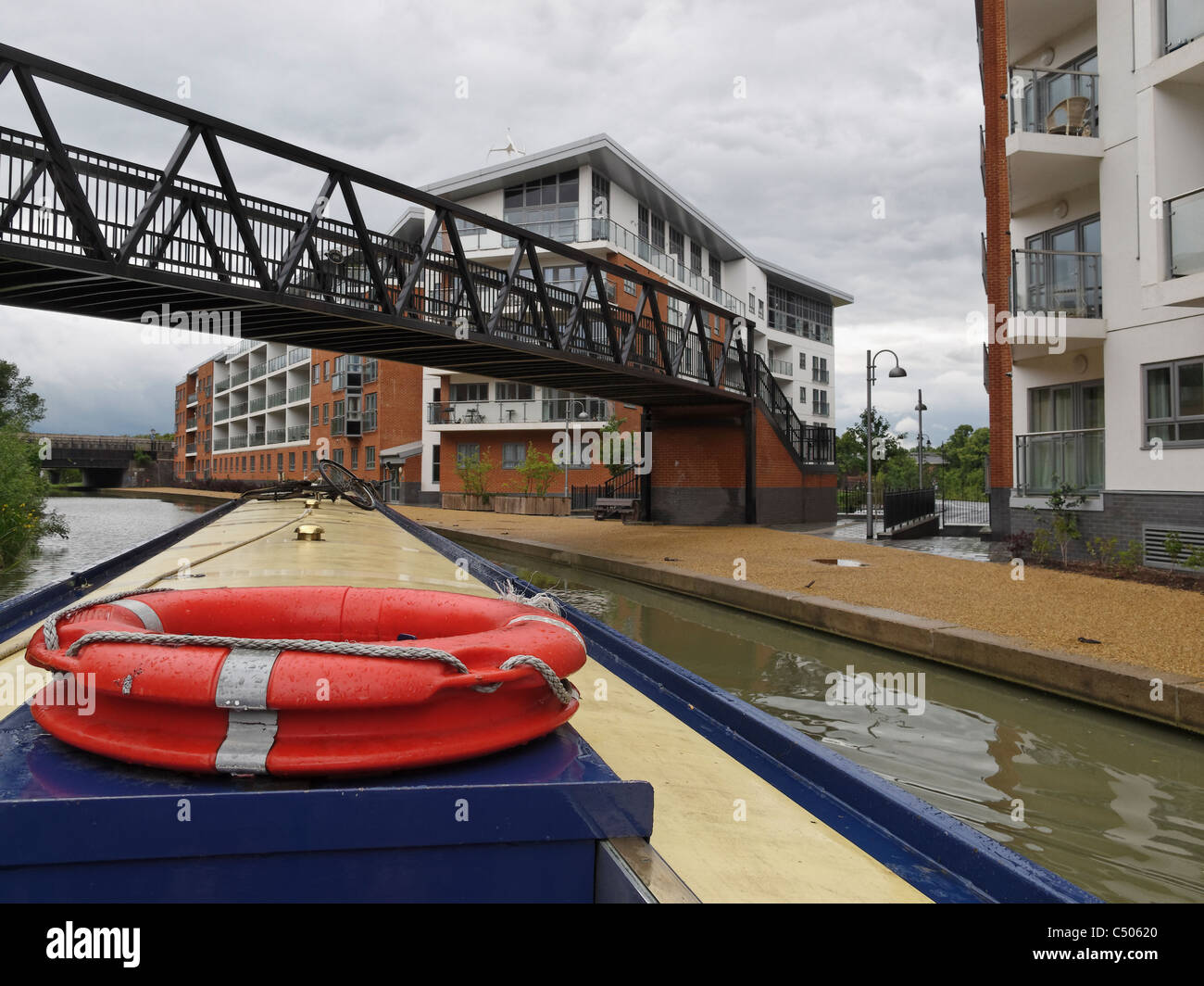 A narrow boat passing through an urban landscape on the Grand Union ...
