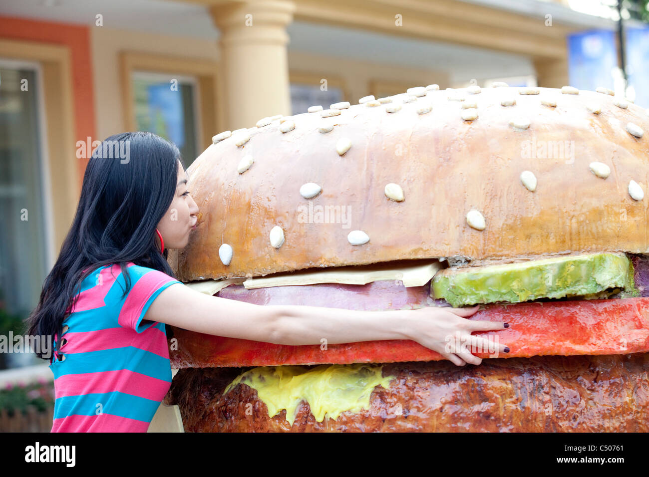 Young Woman Having Fun with a Fake Burger Stock Photo - Alamy