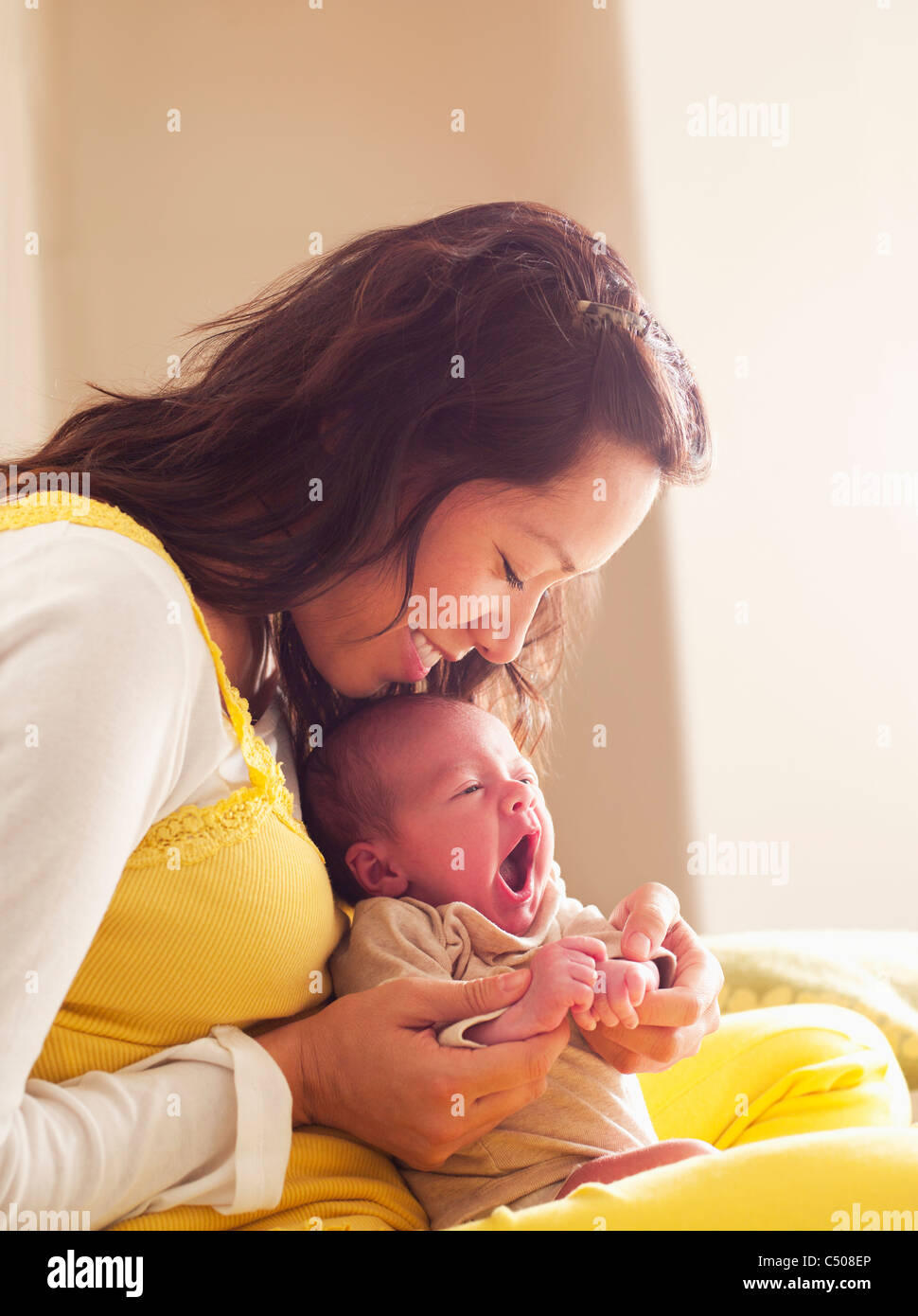 Mother holding newborn baby in her lap Stock Photo - Alamy