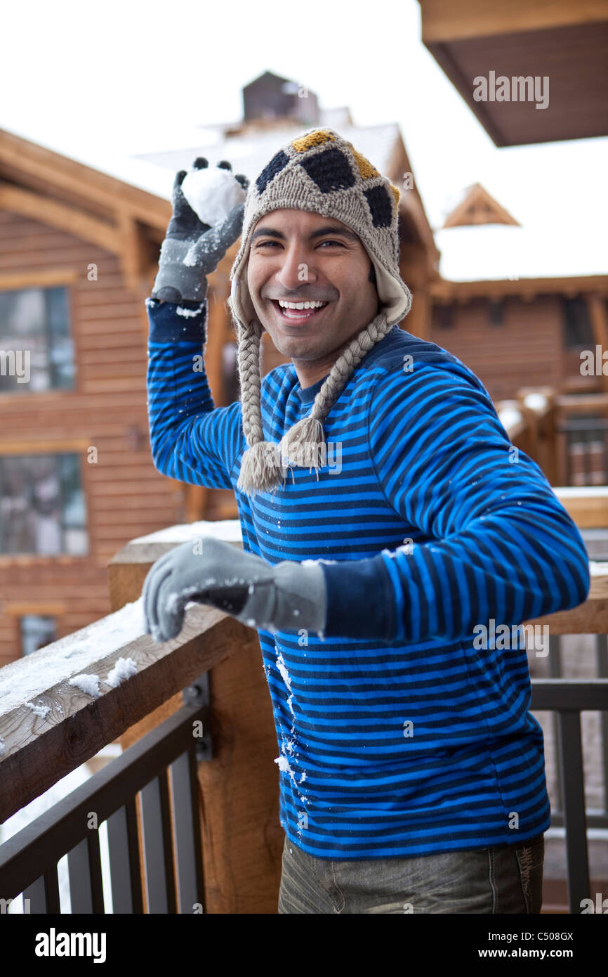 Smiling man throwing snowball Stock Photo - Alamy