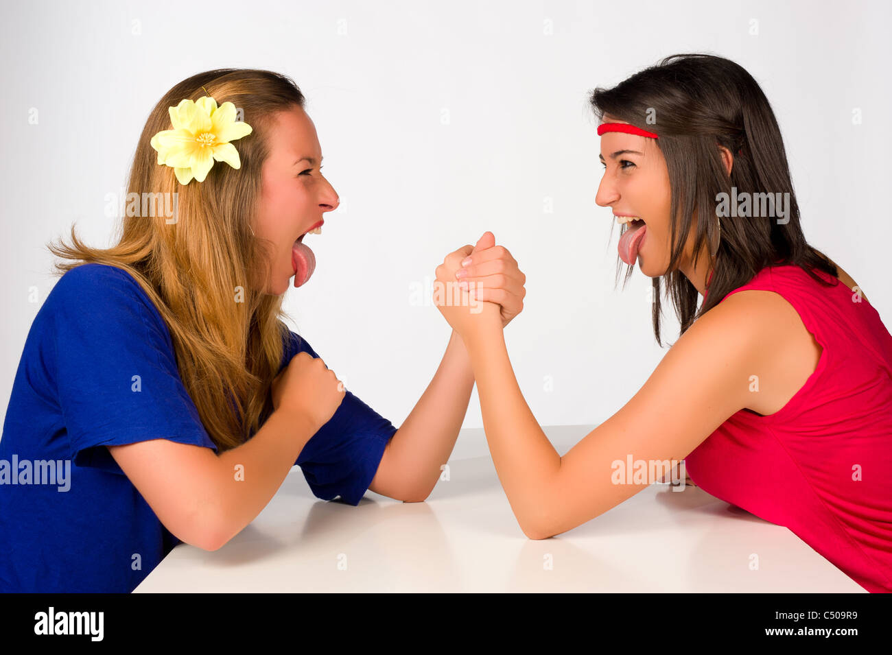 Blond and brunette girl at a crazy arm wrestling contest Stock Photo ...