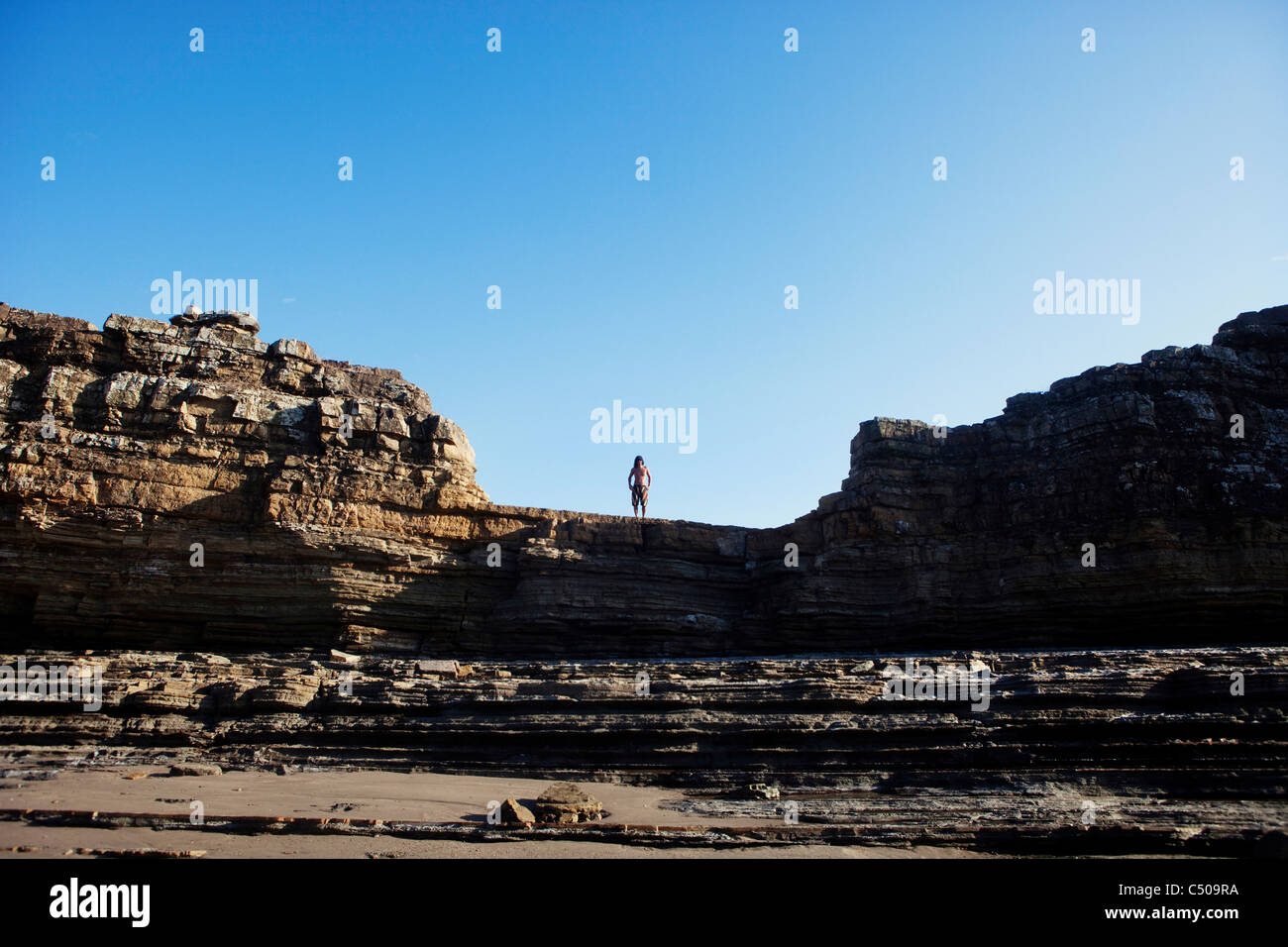Asian man standing on cliff's edge Stock Photo - Alamy