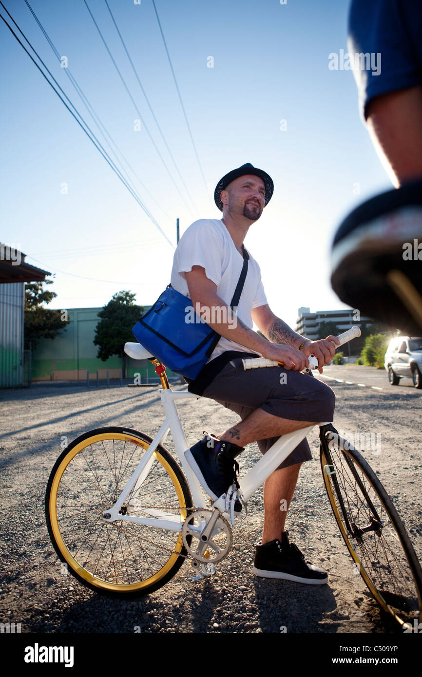 Bicycle messenger stopping on city street Stock Photo - Alamy