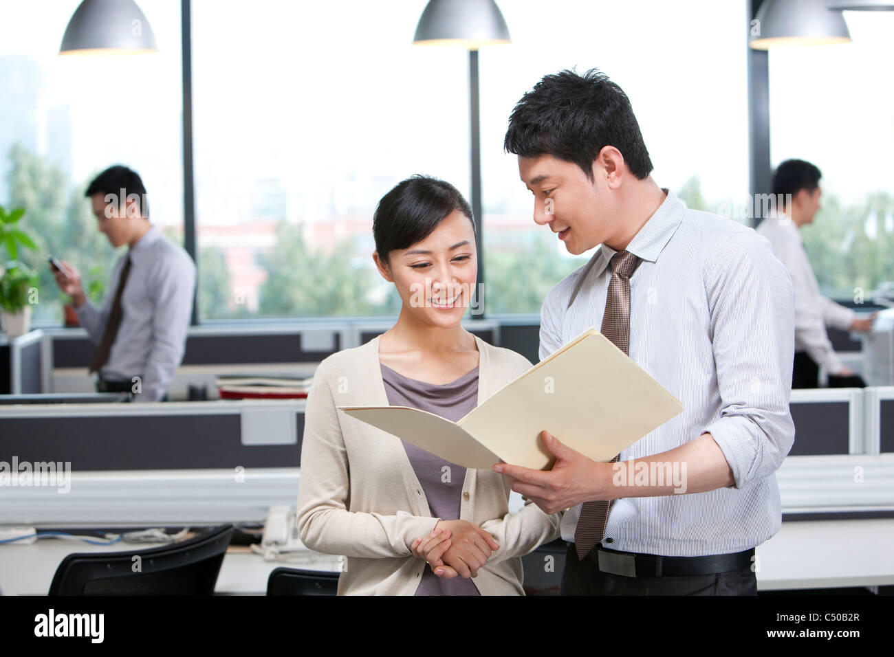 Coworkers looking over report Stock Photo - Alamy