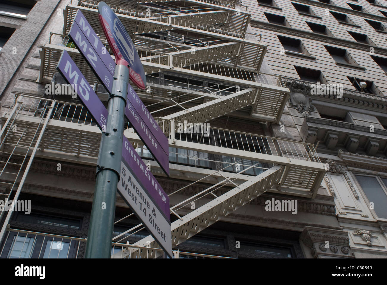 A signpost lists the buses at the bus stop on 14th Street in New York ...