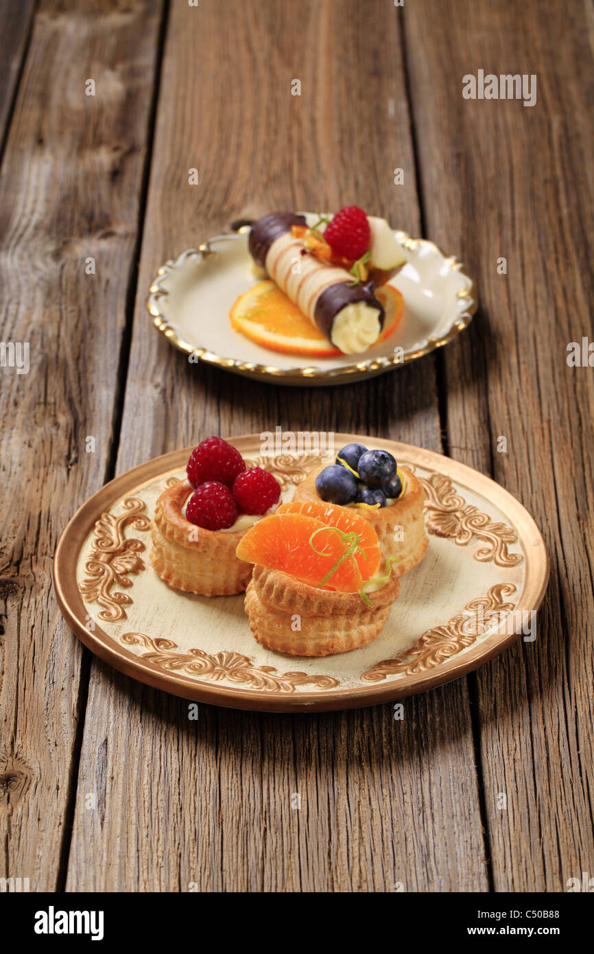 Custard filled puff pastry shells topped with fresh fruit Stock Photo ...