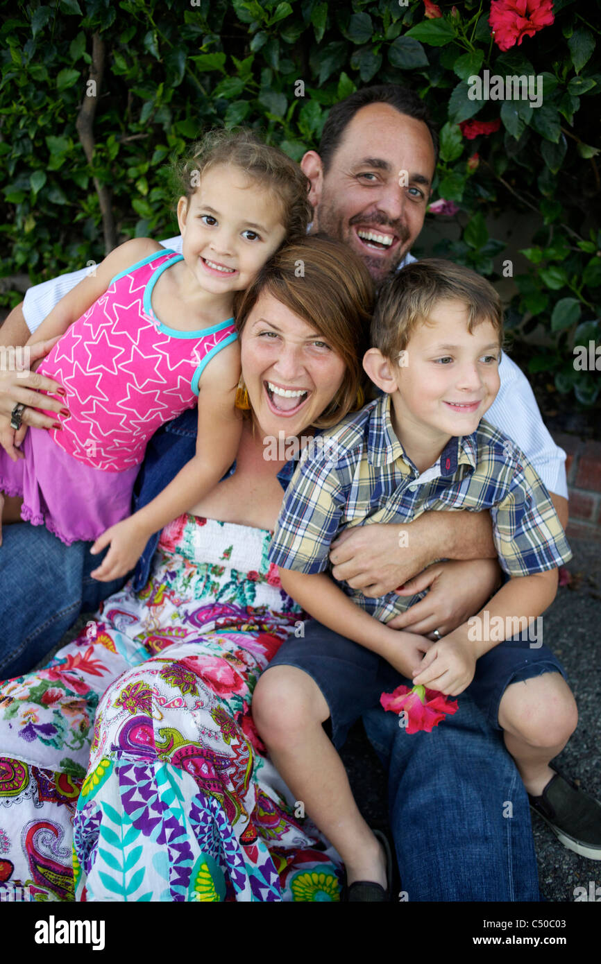 Laughing parents holding children on lap Stock Photo - Alamy