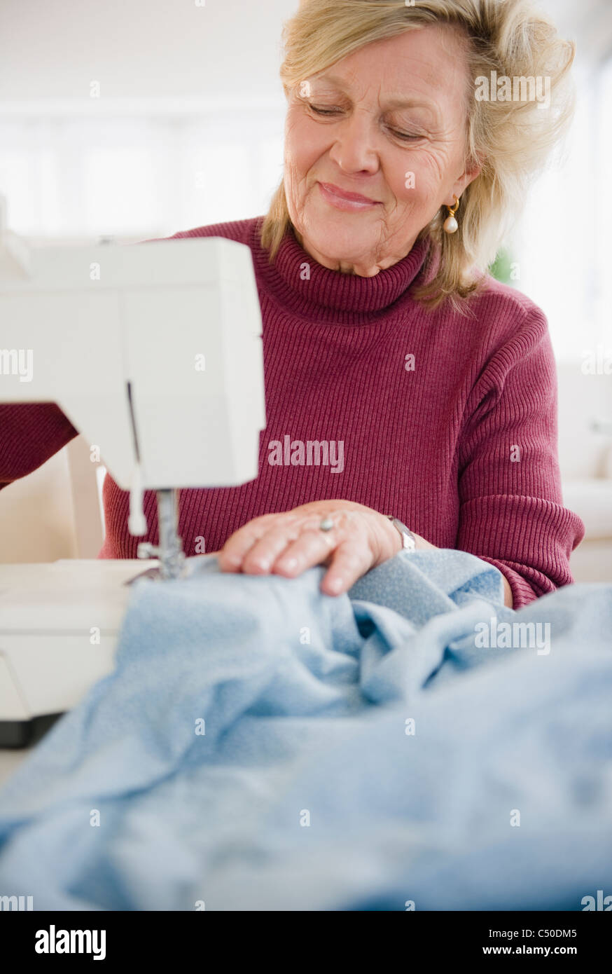 Caucasian woman using sewing machine Stock Photo - Alamy