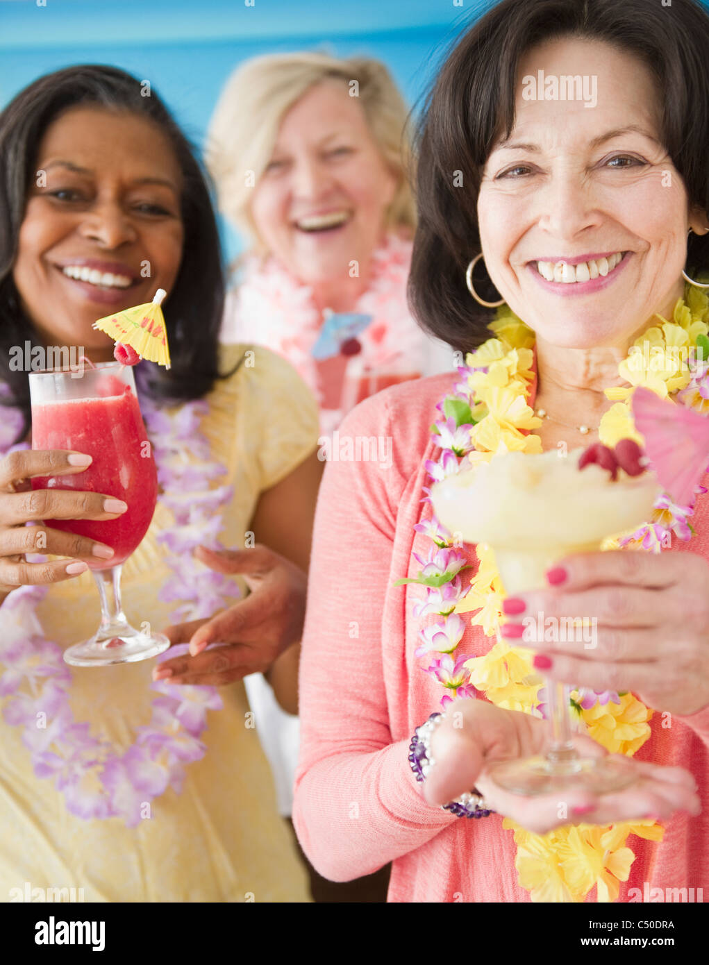 Friends drinking tropical cocktails together Stock Photo - Alamy