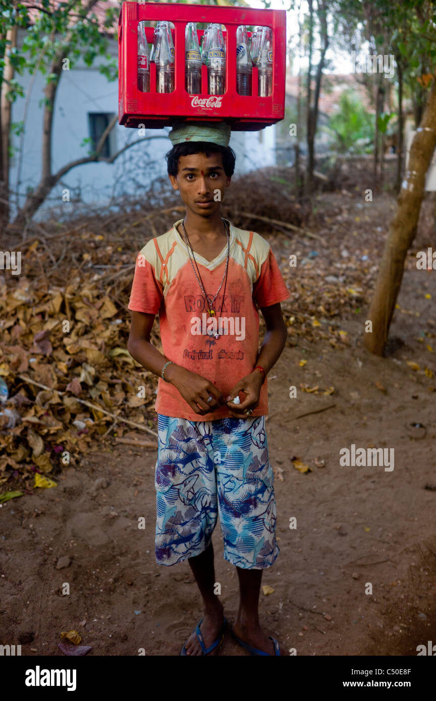 Indian youth carrying coca cola boxes on their heads, Anjuna, Goa ...