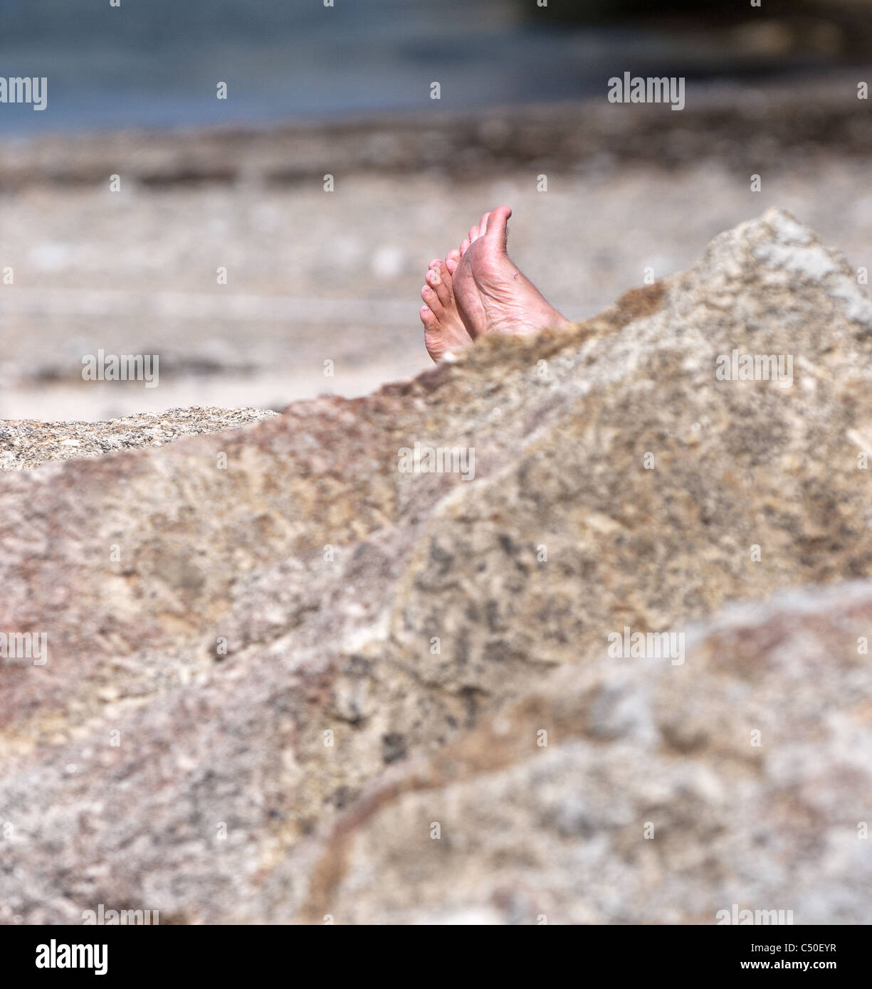 A pair of feet resting on a rock Stock Photo - Alamy
