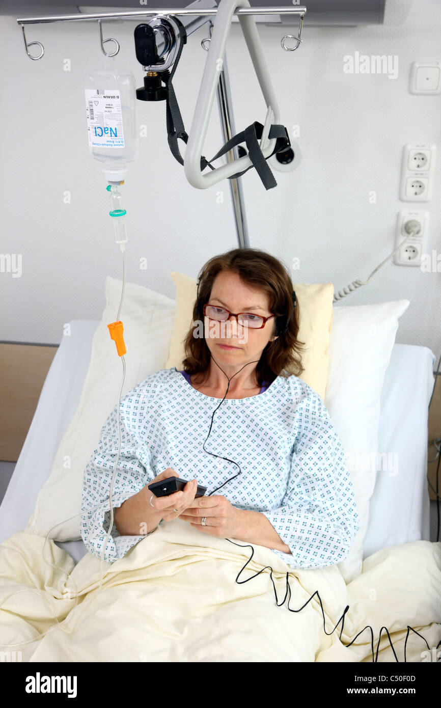 Hospital. Female patient in her bed, watching television, using a ...