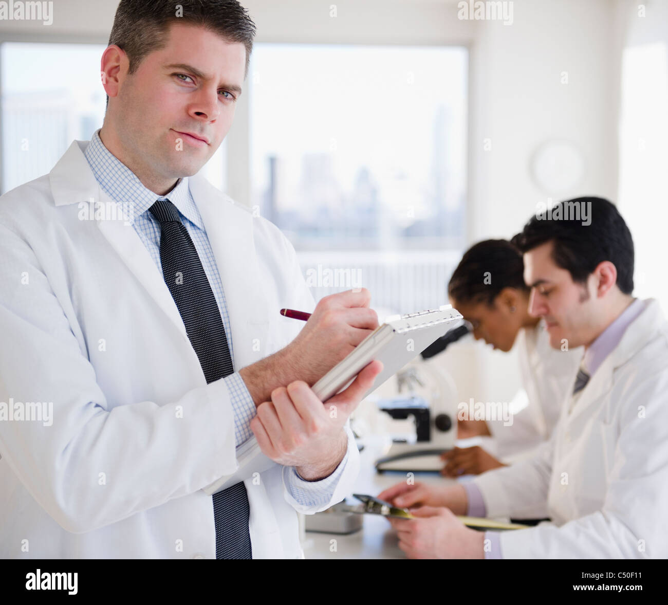 Scientist writing on clipboard in laboratory Stock Photo - Alamy