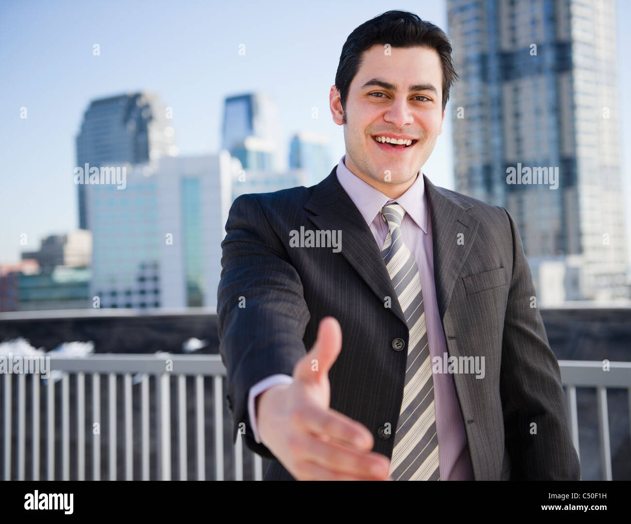Hispanic businessman with hand outstretched Stock Photo - Alamy