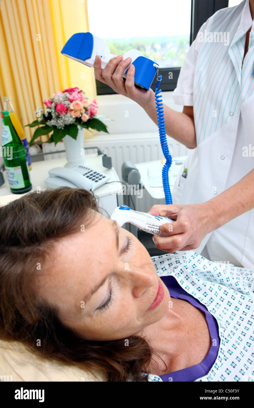 Hospital. Nurse measuring body temperature of a female patient, with a ...
