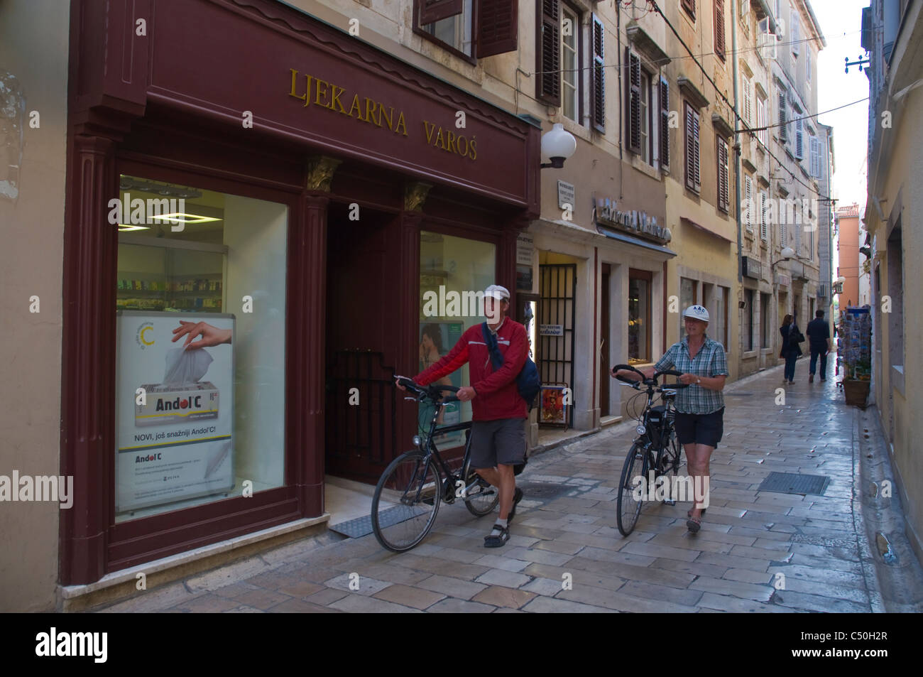 Tourists with bicycles along Siroka Ulica street in Stari Grad the old ...