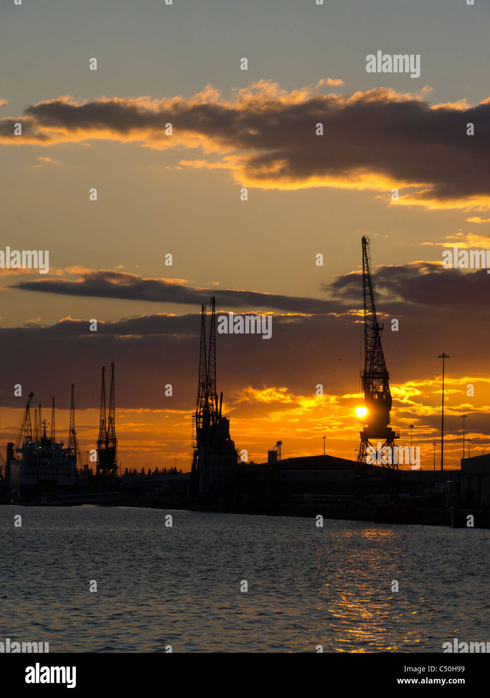 Stormy sunset with cranes and ships in Southampton, Hampshire, England ...