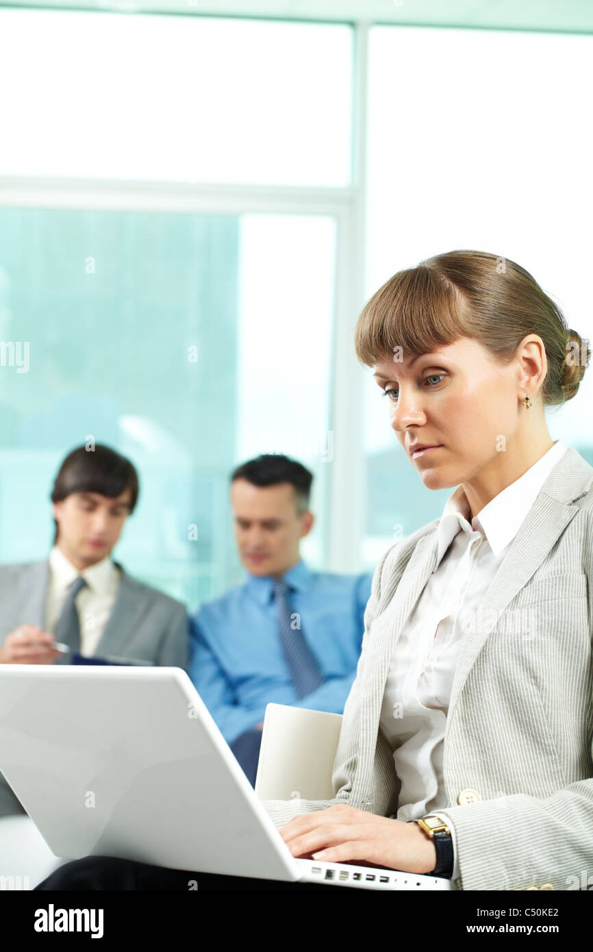 Portrait of pretty secretary looking at laptop screen in working ...