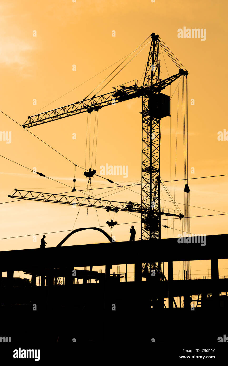 Two construction cranes and construction workers on site Stock Photo ...