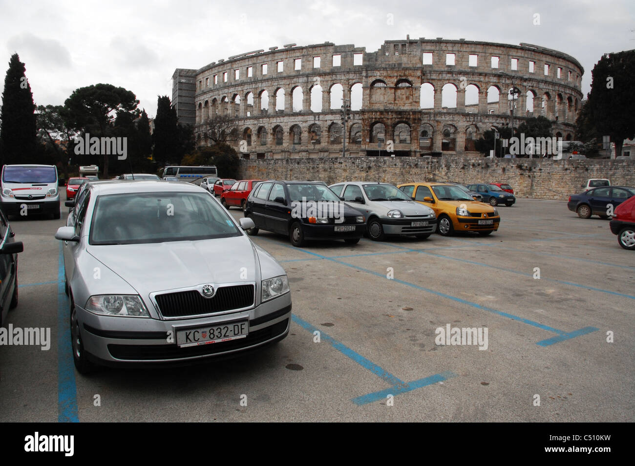 Carpark with parked cars in front of the Roman Amphitheater in Pula ...