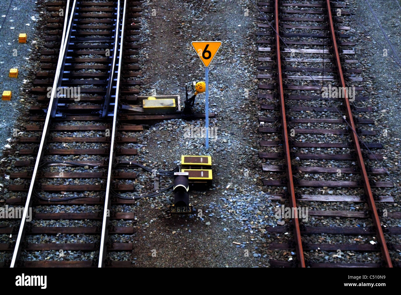 Yellow sign between two railway tracks Stock Photo - Alamy