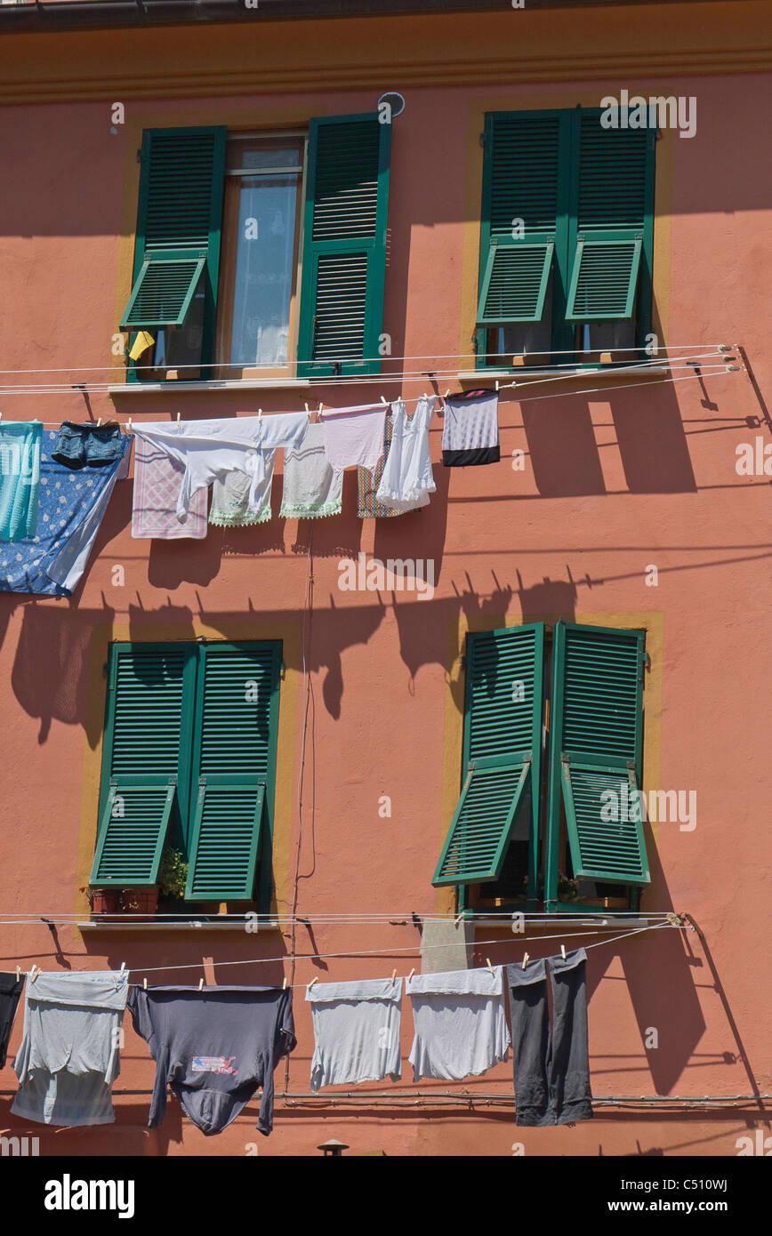 Clothes hang on two clotheslines on a coral colored three story ...