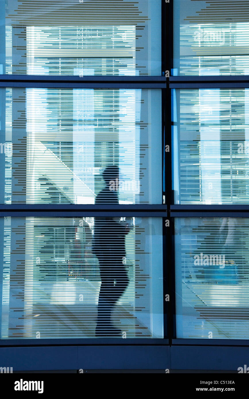 Person inside of modern glass building Stock Photo - Alamy