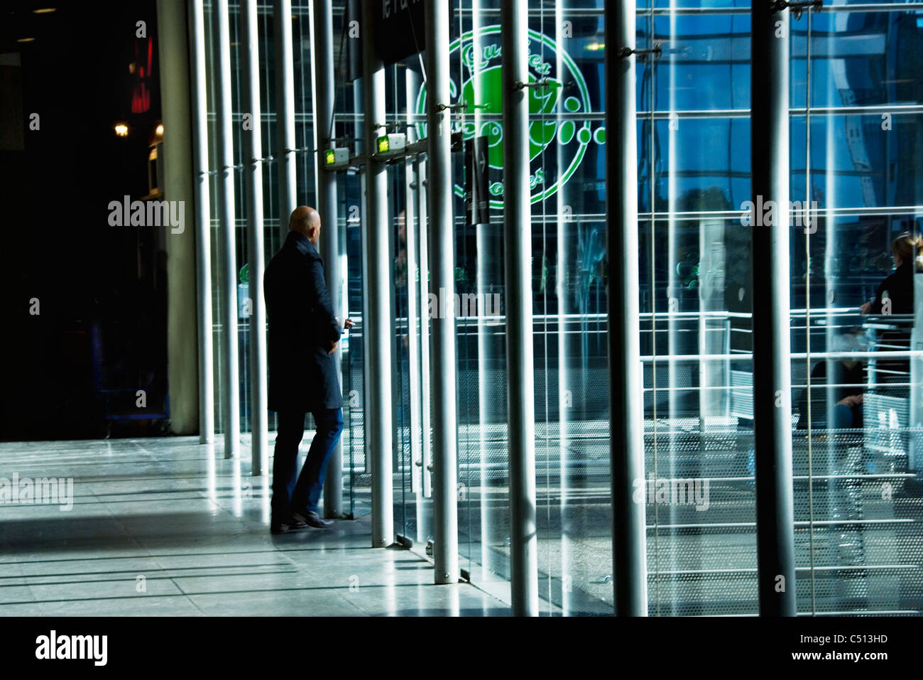 Man leaving modern building Stock Photo - Alamy