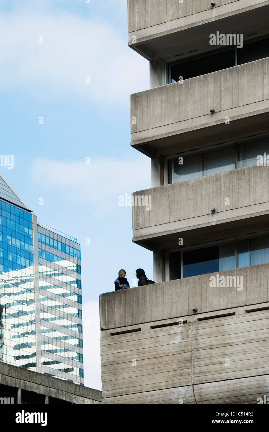Two people talking on balcony of high rise building Stock Photo - Alamy