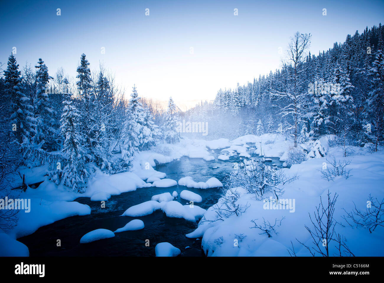 River flowing through a snowy landscape with a rising horizon appearing ...