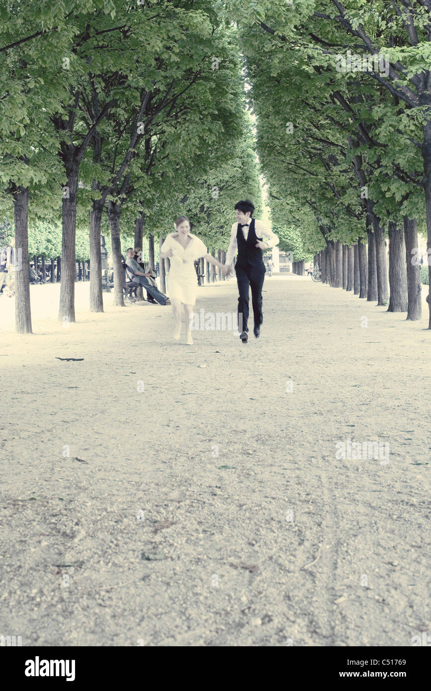 Couple running along rows of trees Stock Photo - Alamy