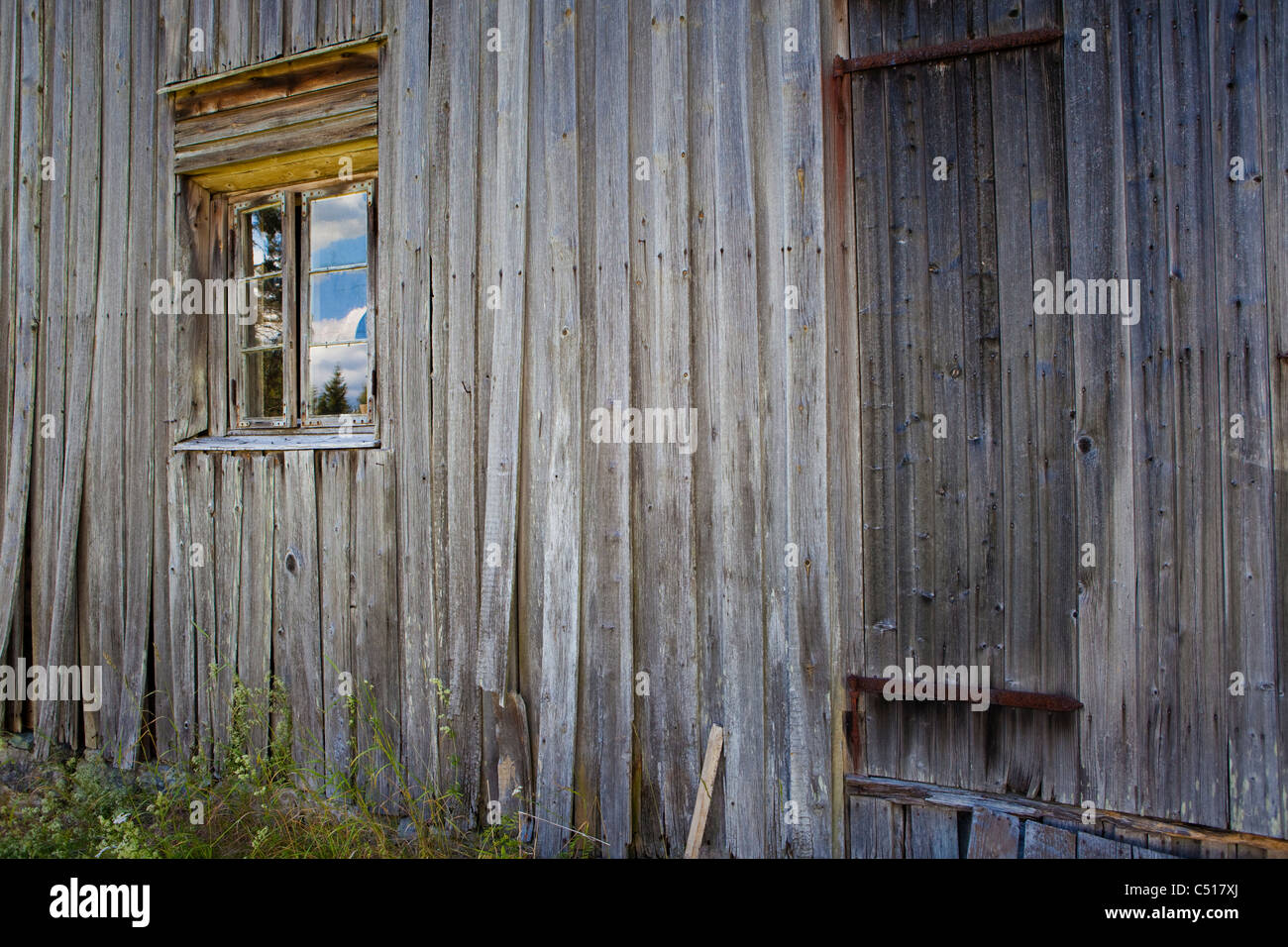 Old wooden cabin shed with window reflecting blue sky Stock Photo - Alamy
